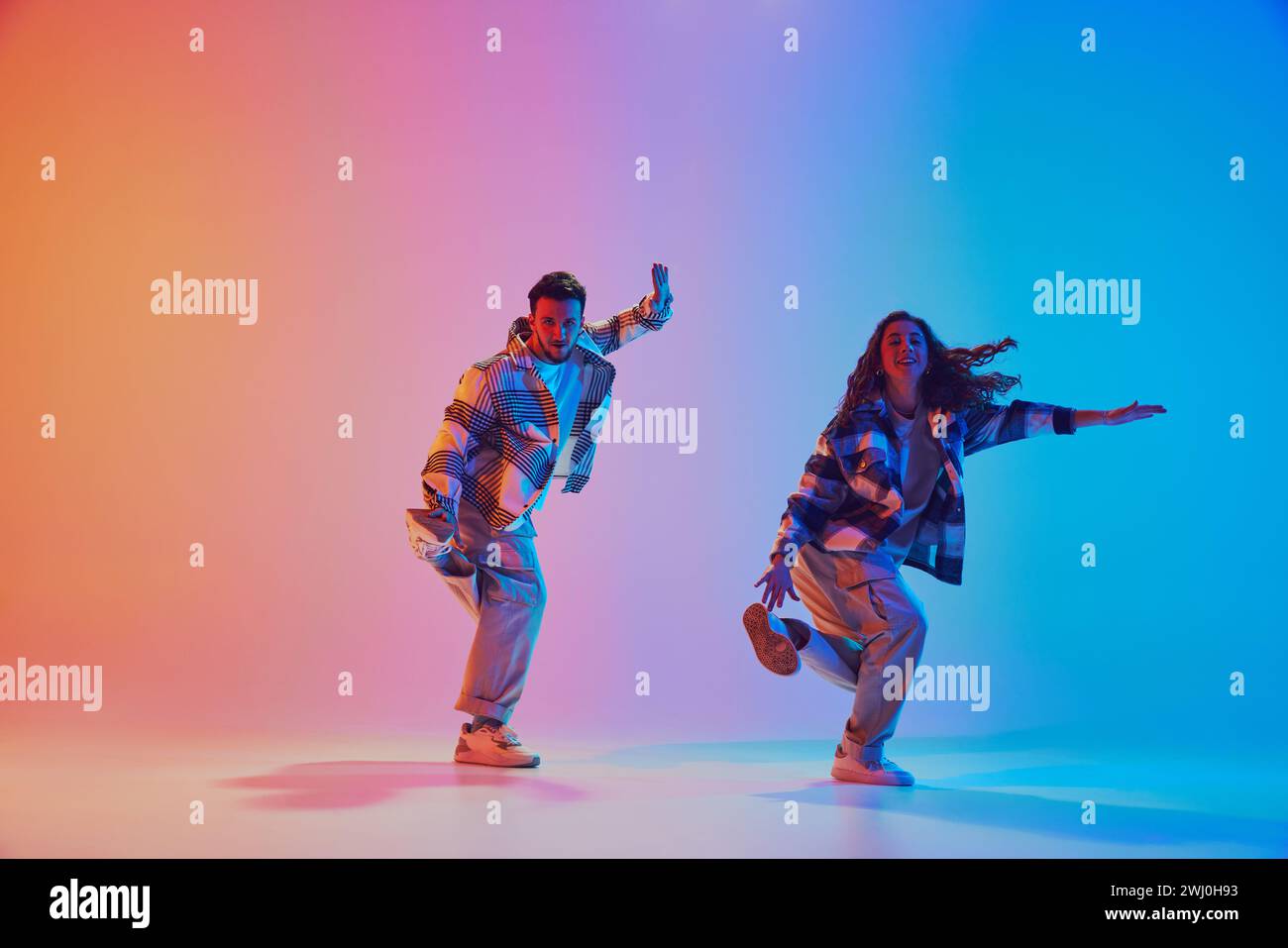 Full length portrait of hip-hop dancers performing in motion against ...