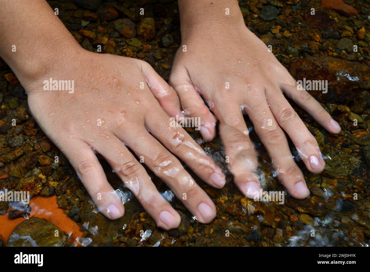 The hand that is being put into the water flow in the river Stock Photo ...