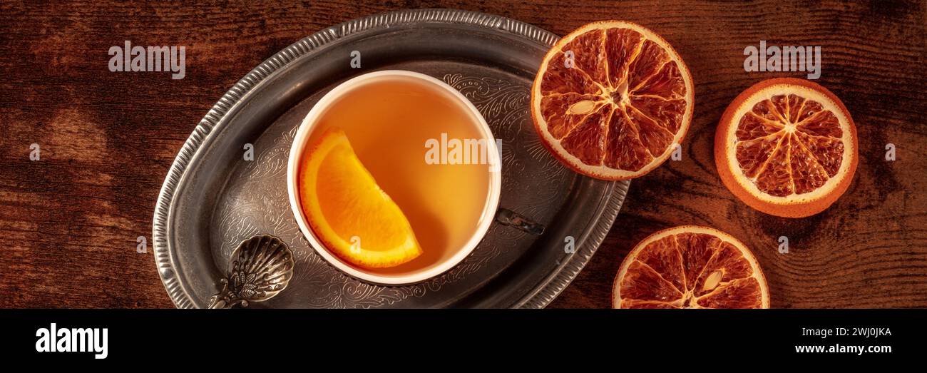 Orange tea with fresh and dried oranges panorama, a cup on a vintage ...