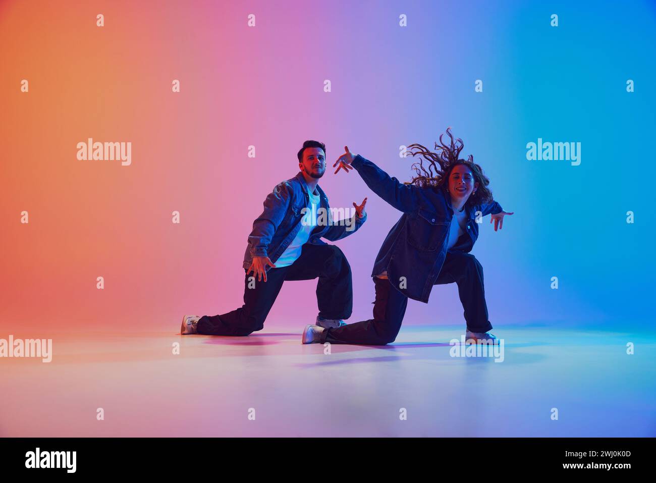 Two young duo dancers training dance moves in motion against gradient ...