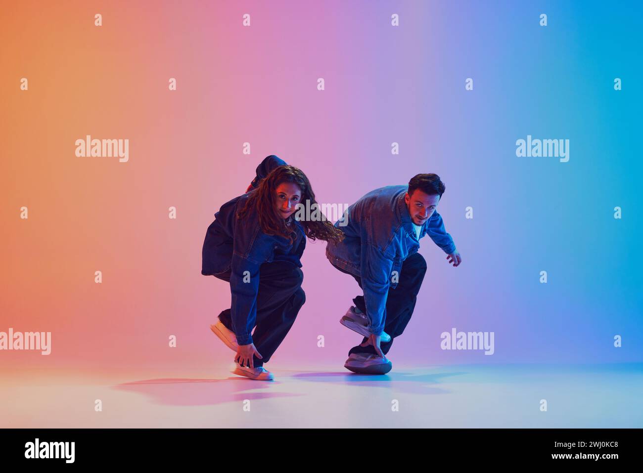 Two dancers performing sync hip-hop moves dressed in denim clothes ...