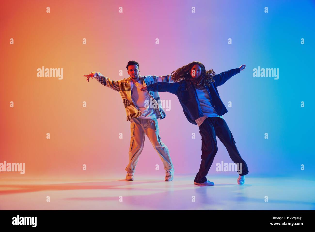 Dynamic photo of two fashion dressed people, dancing in motion against ... Dynamic photo of two fashion dressed people, dancing in motion against ...