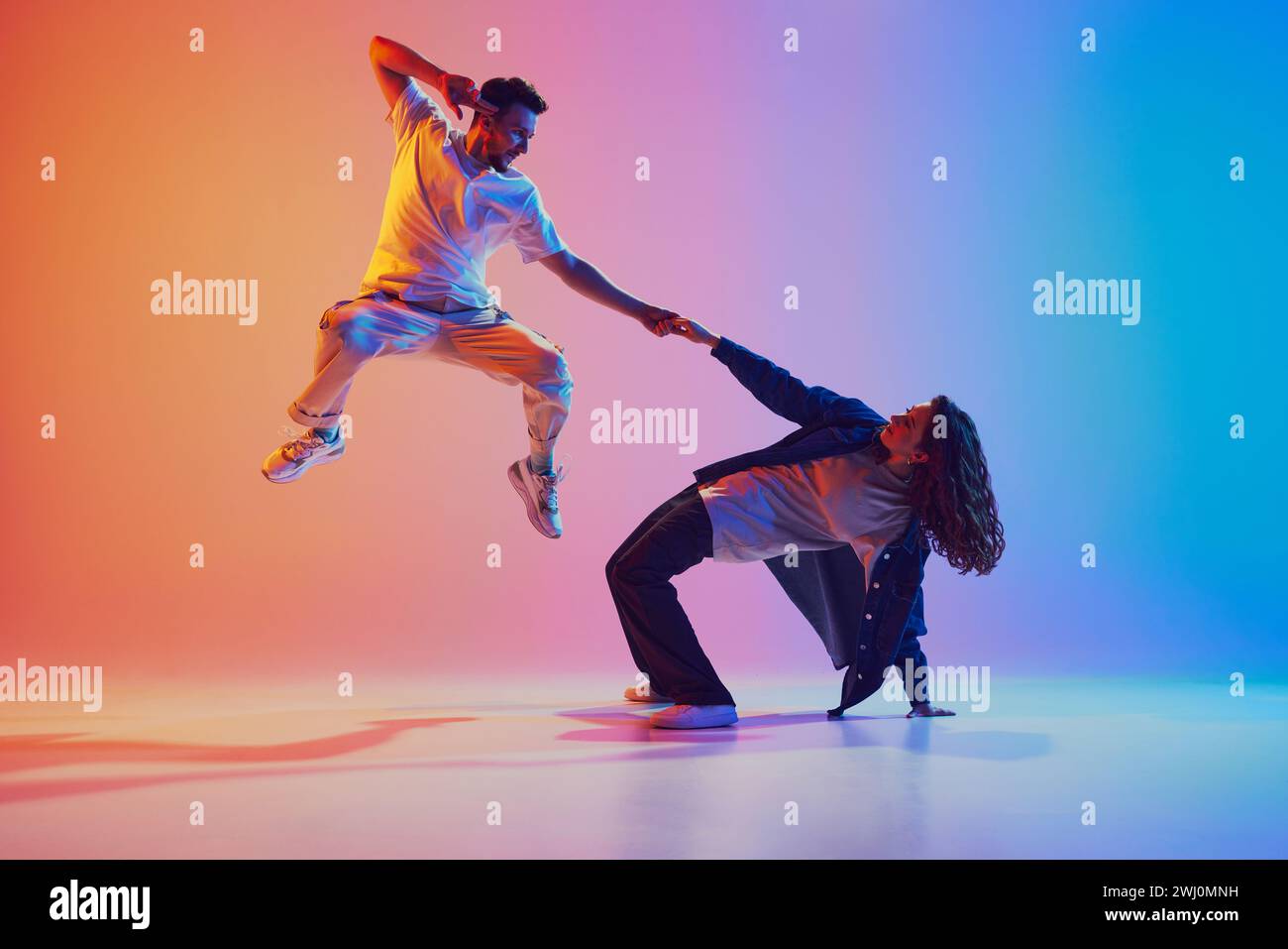 Dynamic photo of man leaping, woman bending backwards against vivid ...