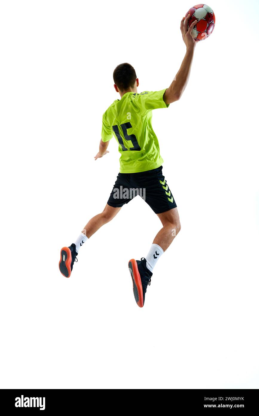 Dynamic back view image of young guy in uniform handball playing in ...