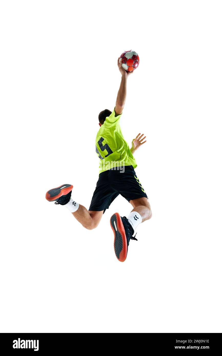 Dynamic back view image of young guy in uniform handball playing in ...