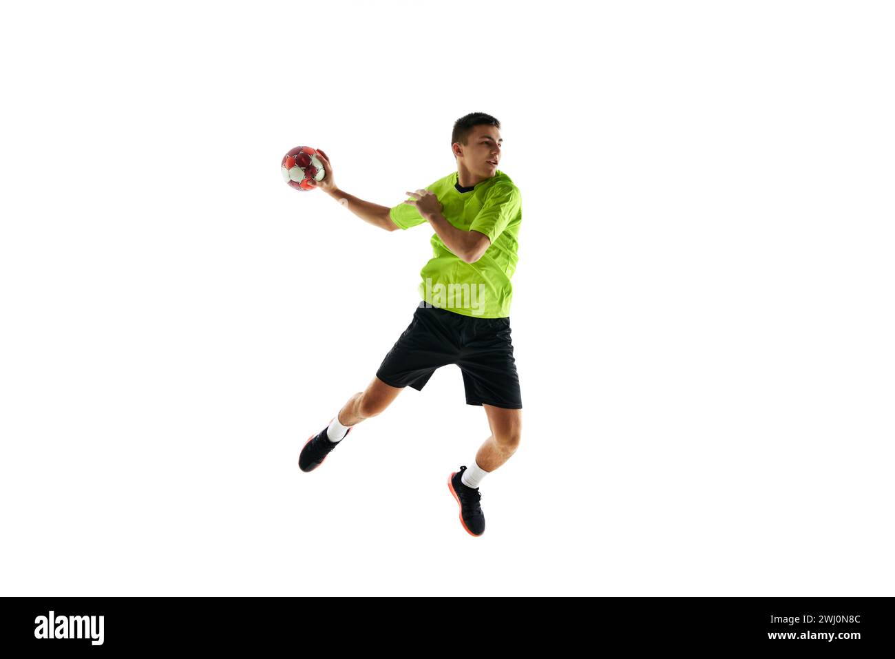 Competitive young guy in uniform, handball player in a jump, throwing ...