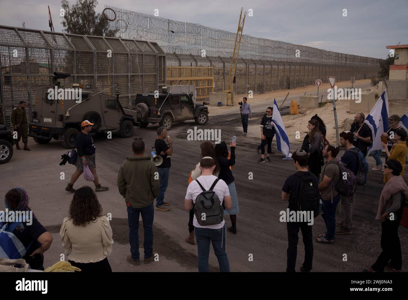 People stand in front of a gate at the Nitzana border crossing with ...