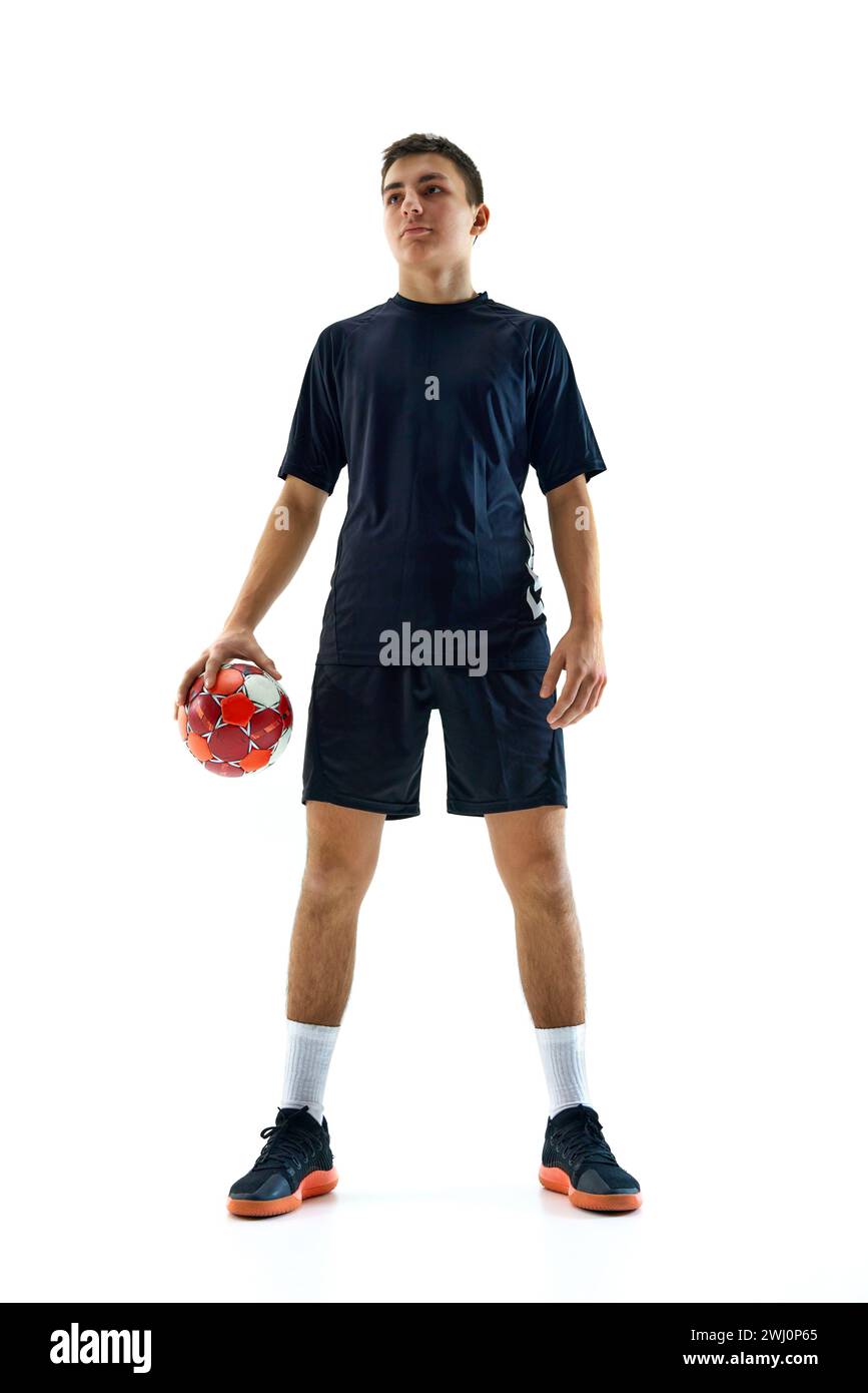 Full-length image of young man, athlete in dark uniform, handball ...