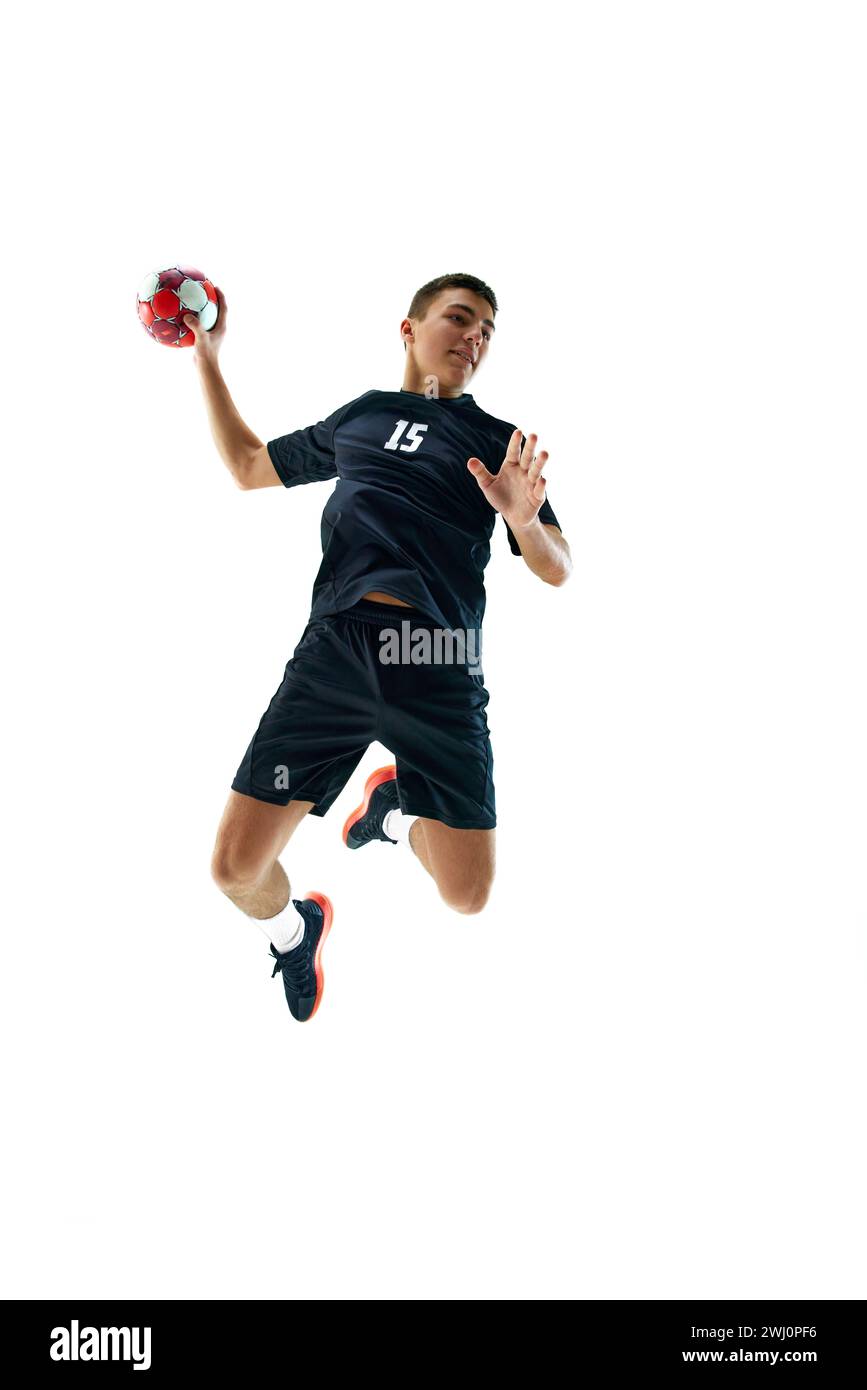Young guy in uniform, handball player in a jump, throwing ball during ...