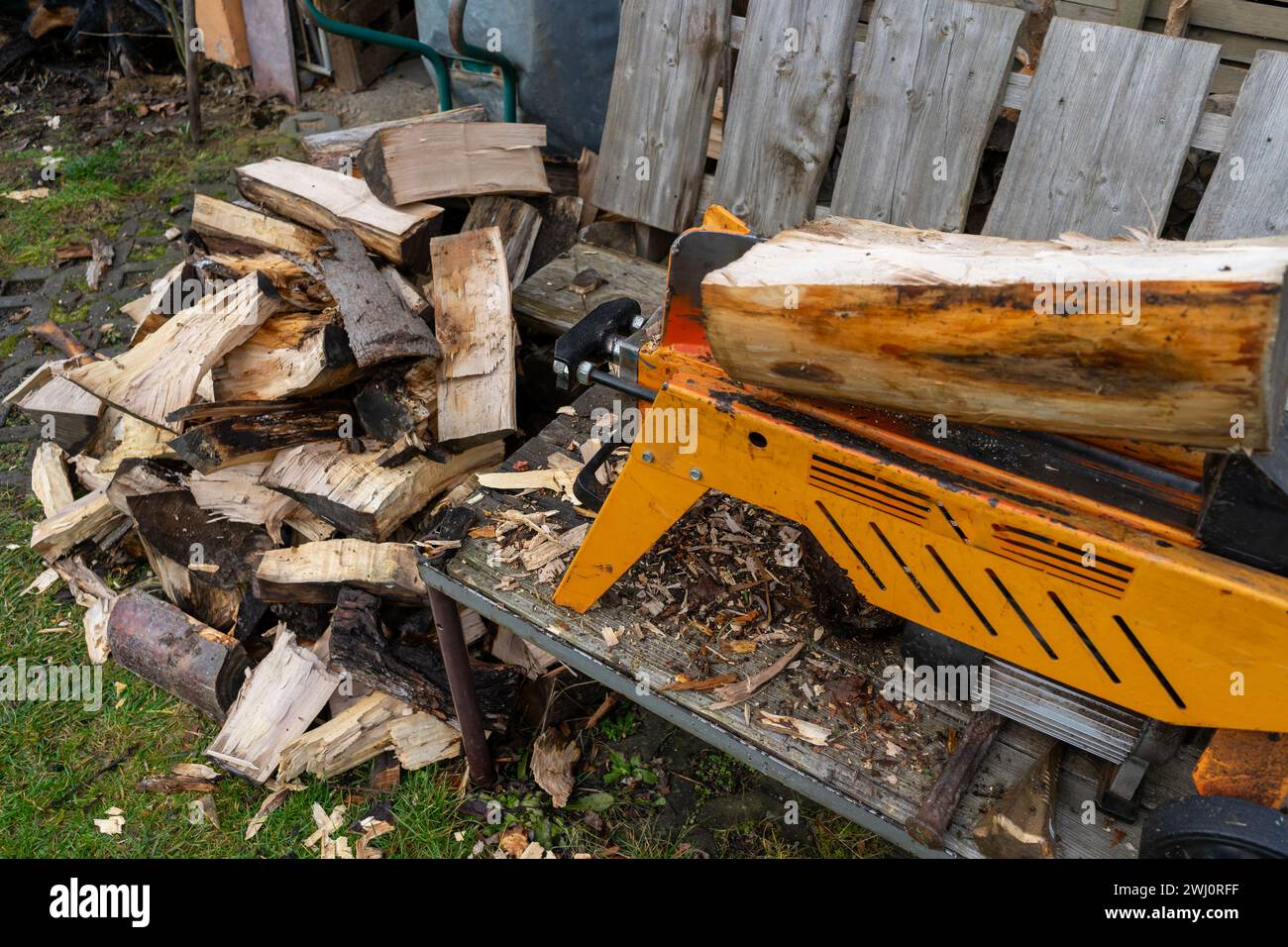 pile of firewood with a log splitter in the garden Stock Photo - Alamy