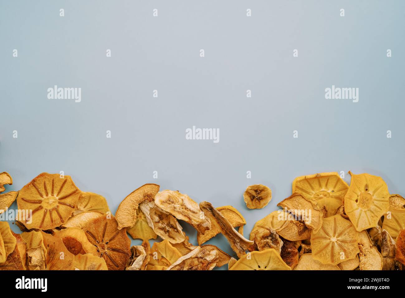Brown pieces of dried fruits lie along the bottom edge on a blue ...