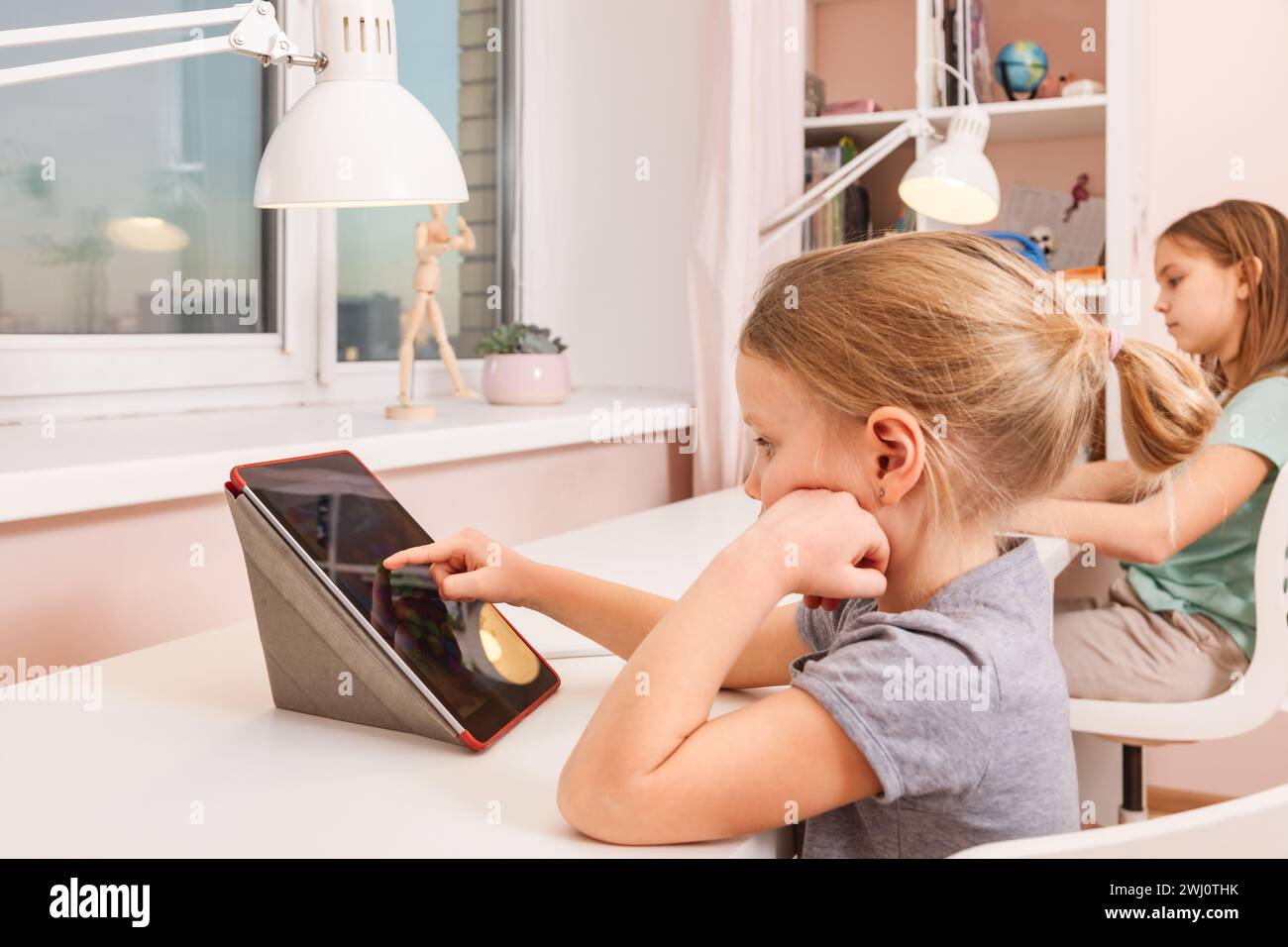 Young girl with her chin propped up in her hand learning educational ...