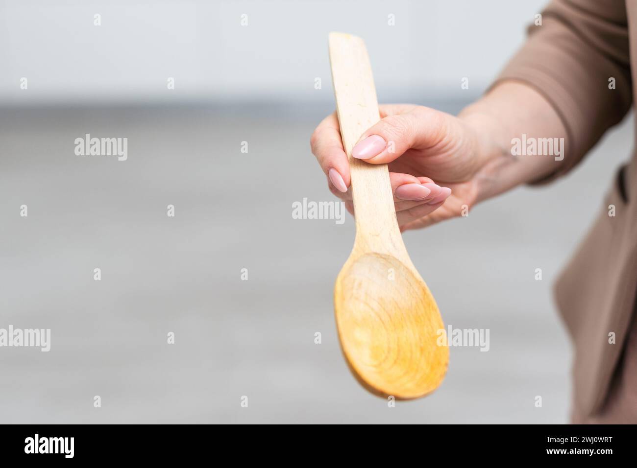 Wooden spoon in hand isolate Stock Photo - Alamy