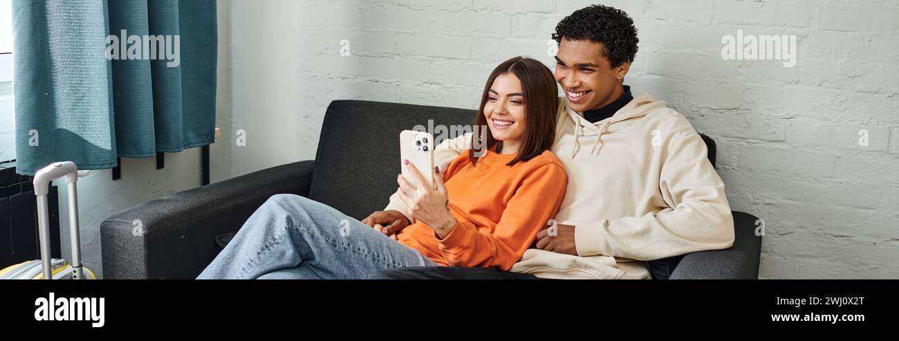 happy diverse couple shares a cozy moment, scrolling through phones on ...
