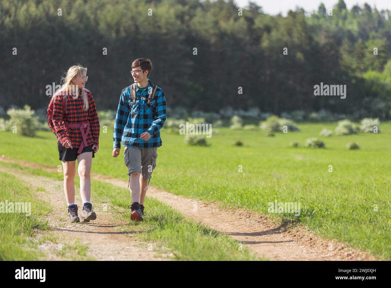 Two adolescents, a girl, and a boy, walk, explore, and enjoy the beauty ...