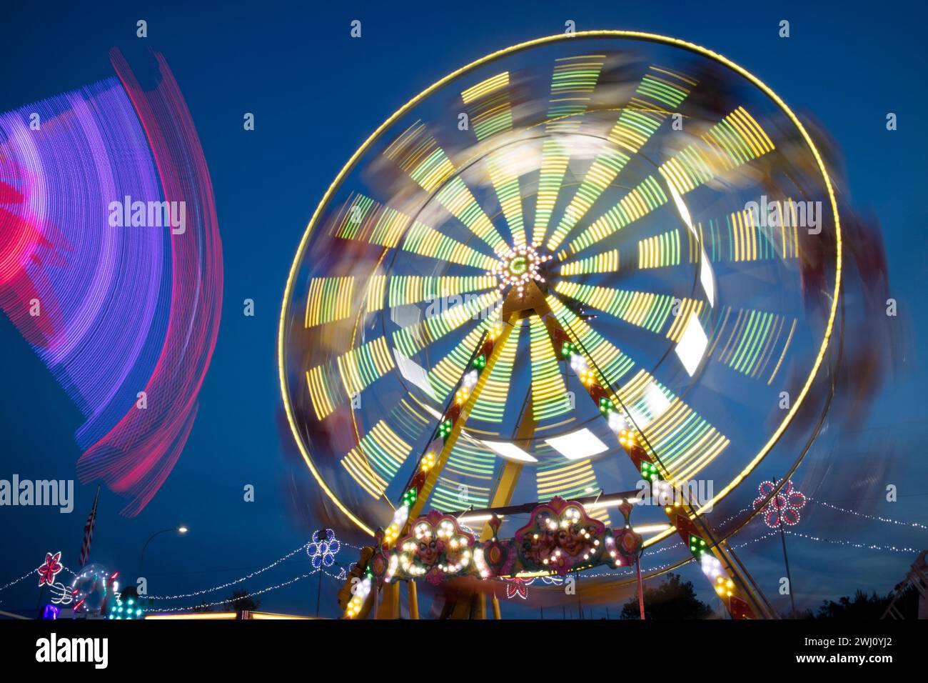 Inside an amusement park the colors of the Ferris wheel Stock Photo - Alamy