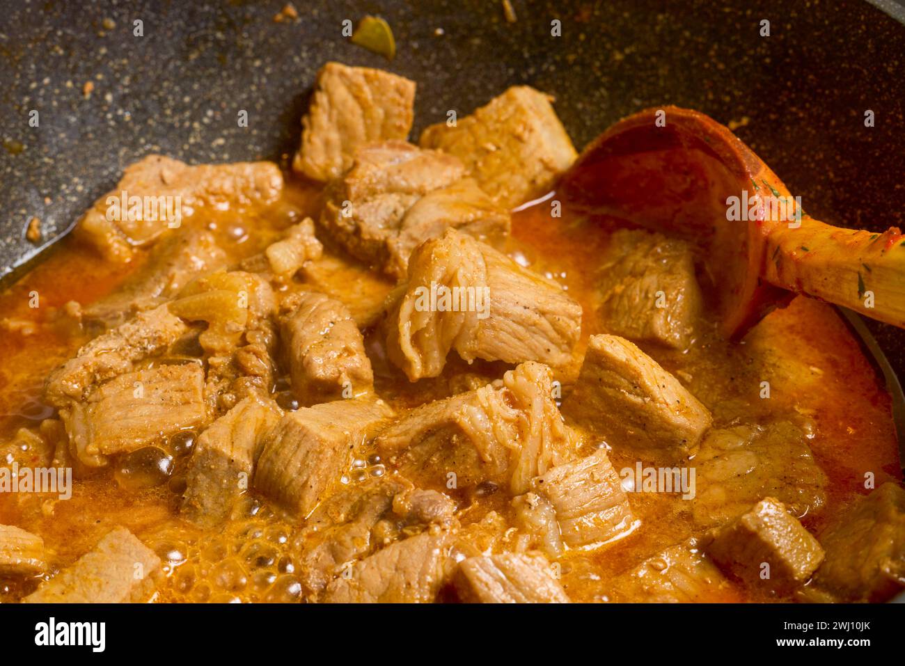 Pork cut into pieces in a wok for cooking Stock Photo - Alamy