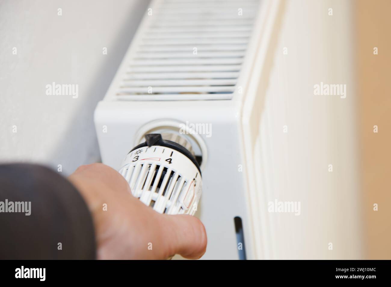 Hand with radiator. Hand regulation Close-up of the heating thermostat ...