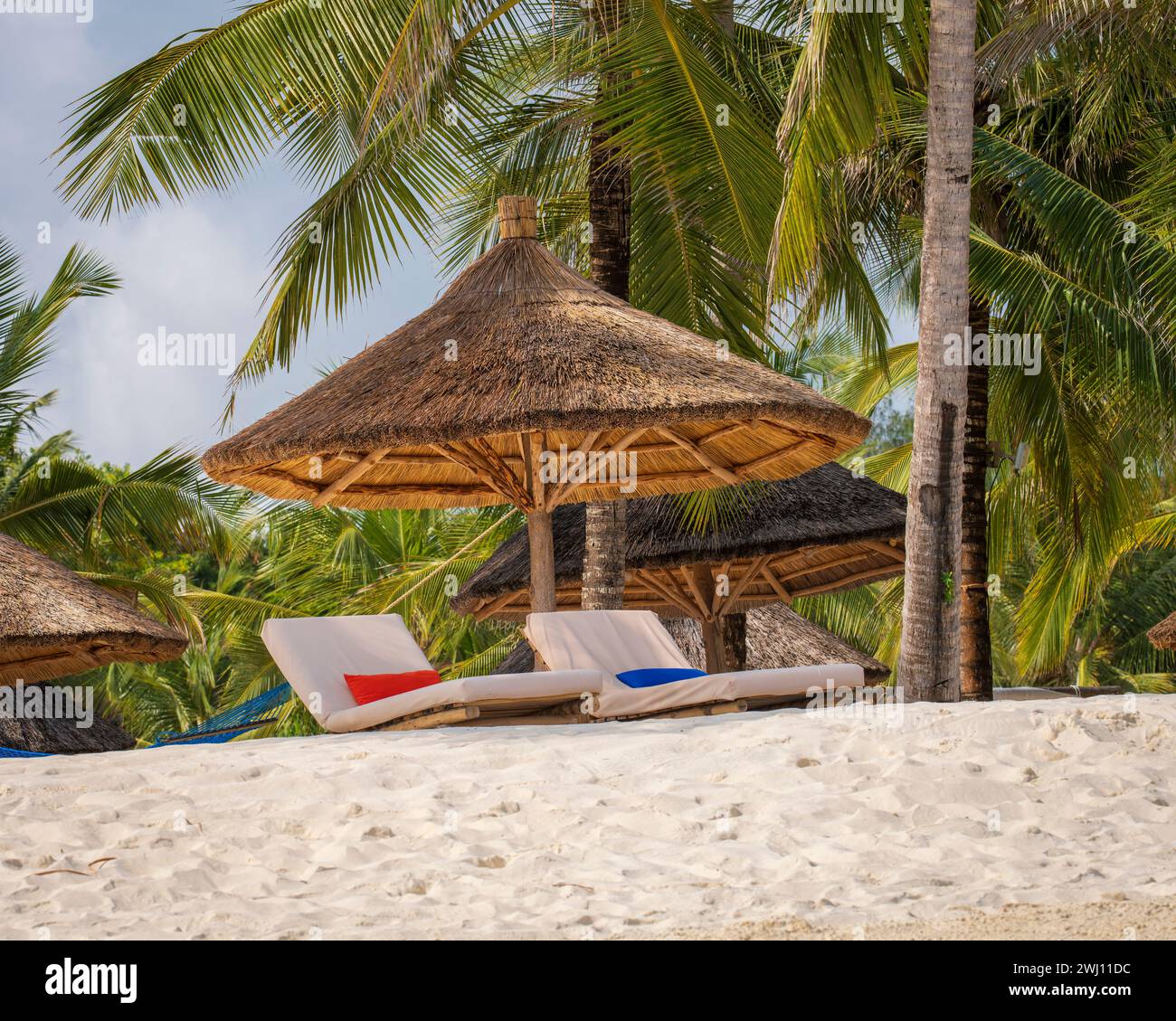 Wooden beach parasol and beach loungers at sunset.Luxury beach parasol ...