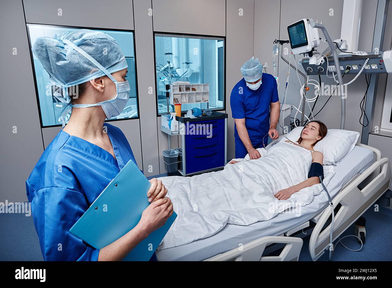 ICU. hospital technicians visiting and caring female patient in ...