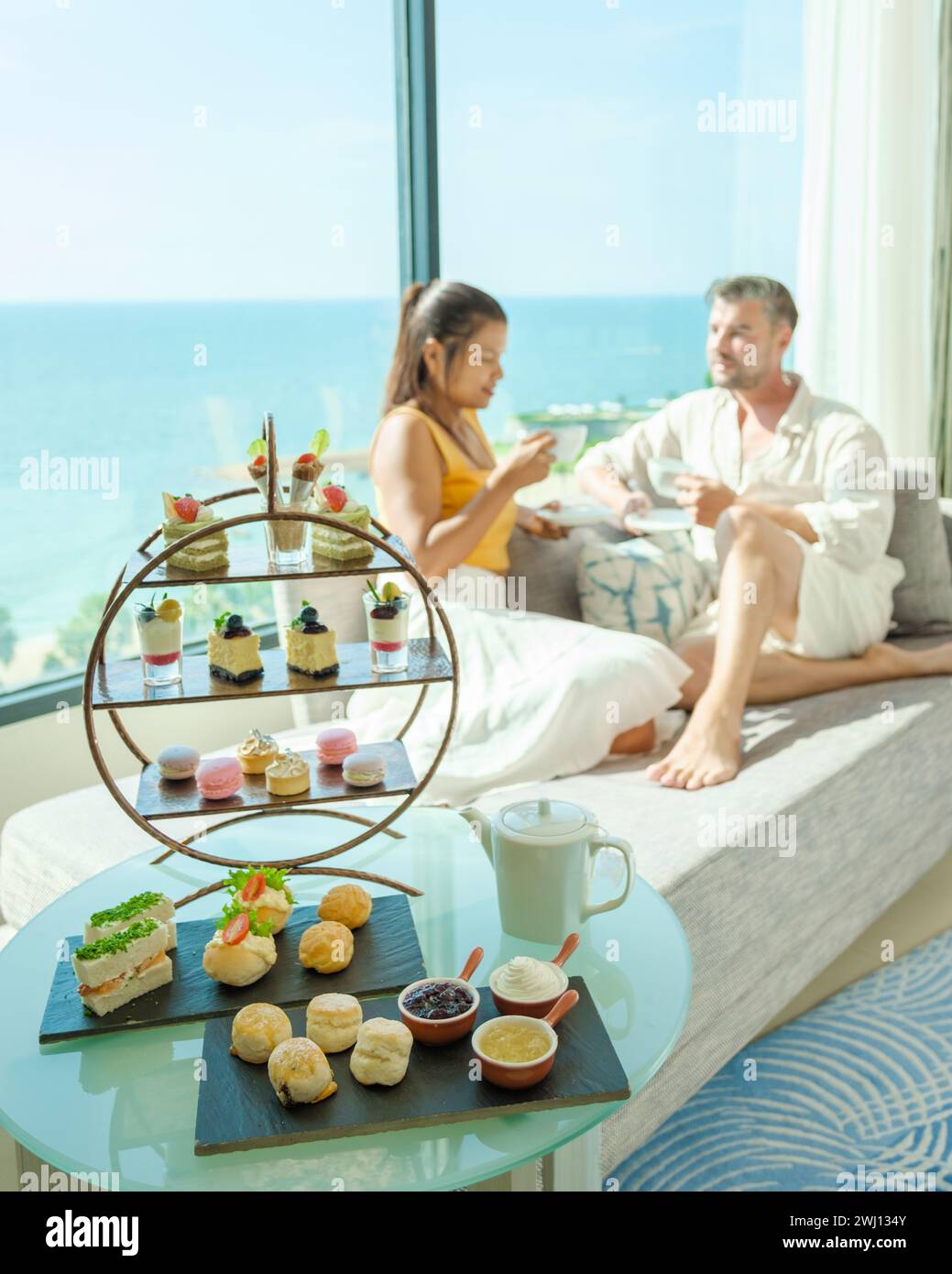 A couple of men and woman having afternoon tea or high tea in a hotel ...
