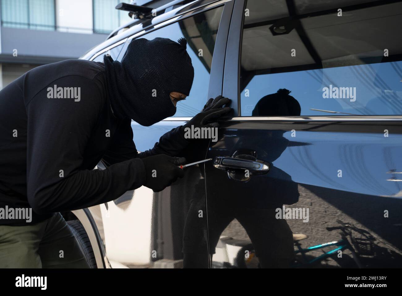 A young man who is breaking into a car Stock Photo - Alamy