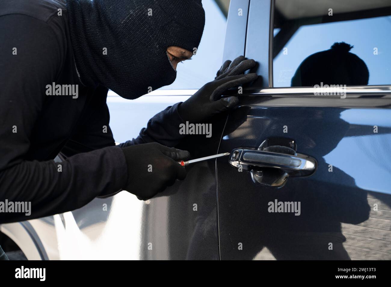 A young man who is breaking into a car Stock Photo - Alamy