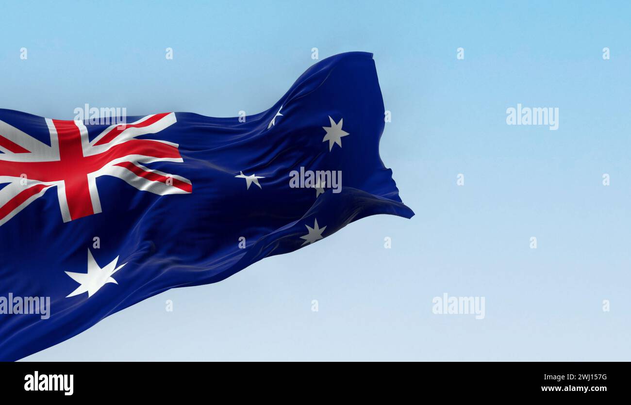 Australian flag waves under cloudy skies, symbol of pride Stock Photo ...
