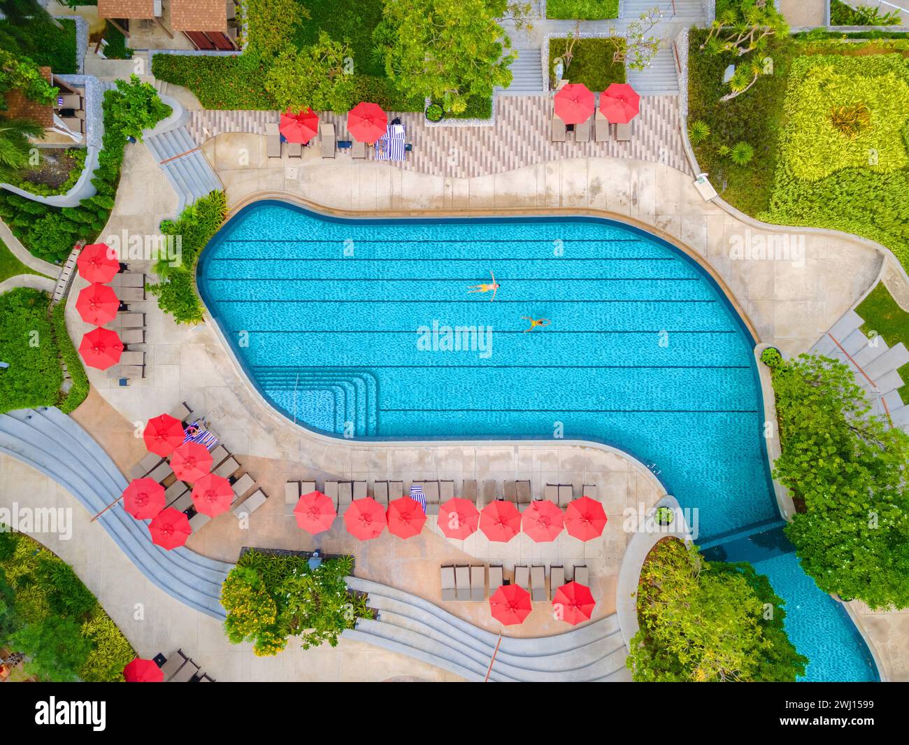 Drone view from above at a couple swimming in an infinity pool on a ...