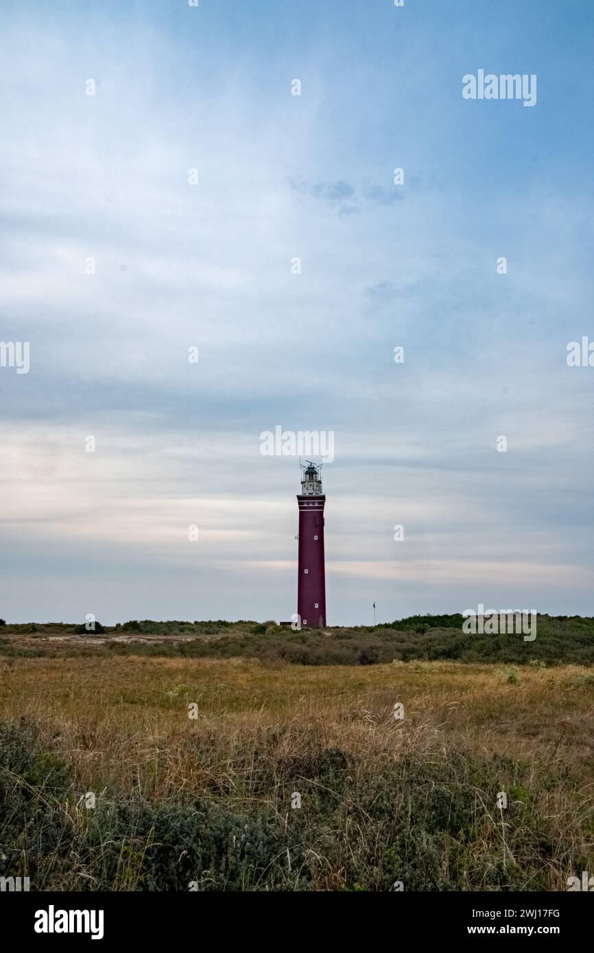 This image presents a solitary red lighthouse rising above a sprawling ...