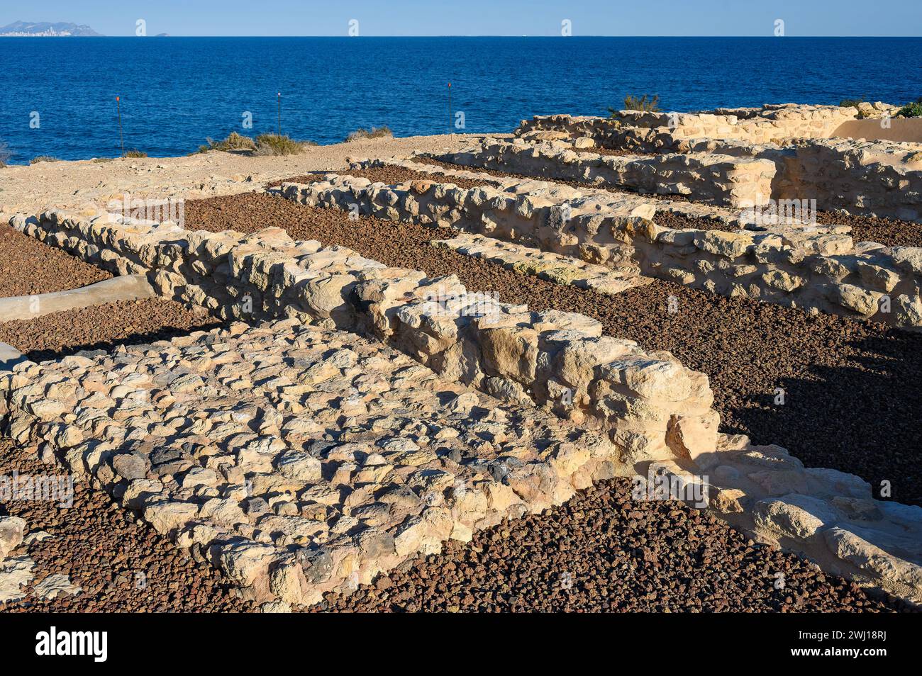 Ruin of stone constructions in La Illeta. The Mediterranean Sea and the ...
