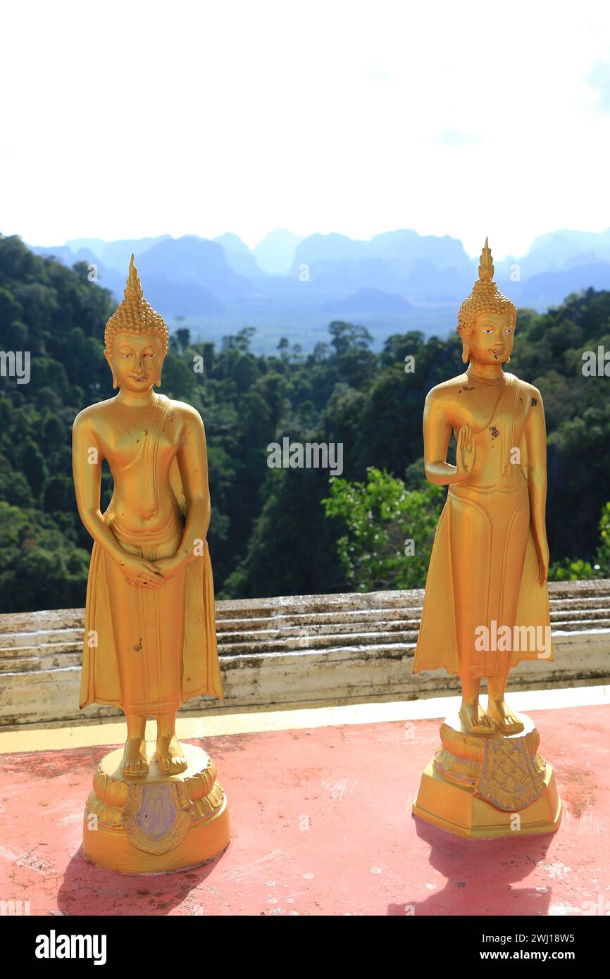 Province of Krabi, Thailand. Two gold statues of Buddha at the top of ...
