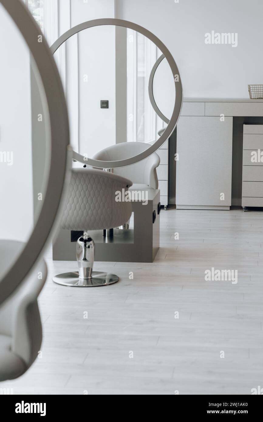 Modern salon interior with empty stylist chairs and circular mirrors ...
