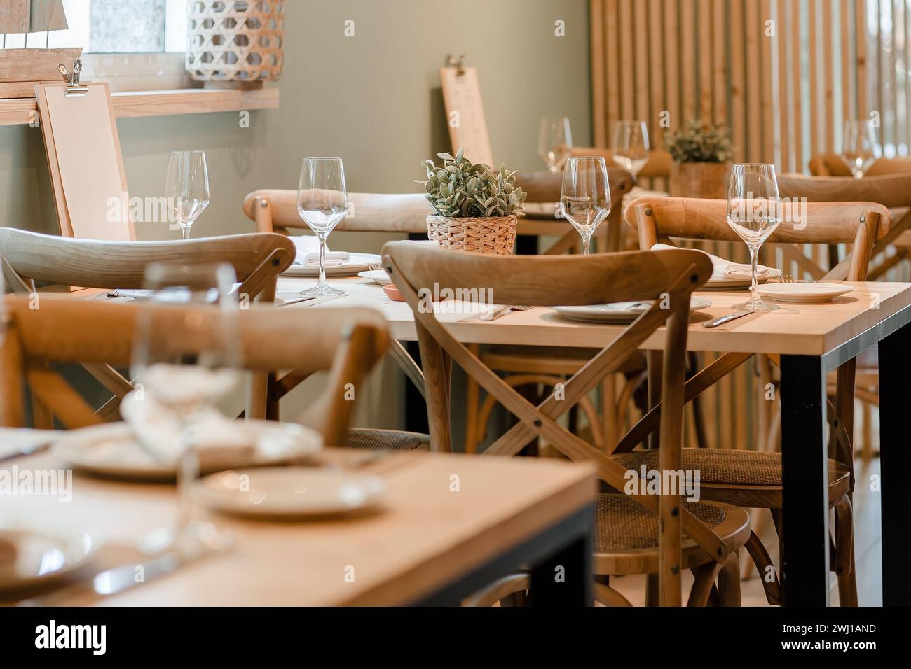 Elegant restaurant setting with wooden tables and wine glasses Stock ...