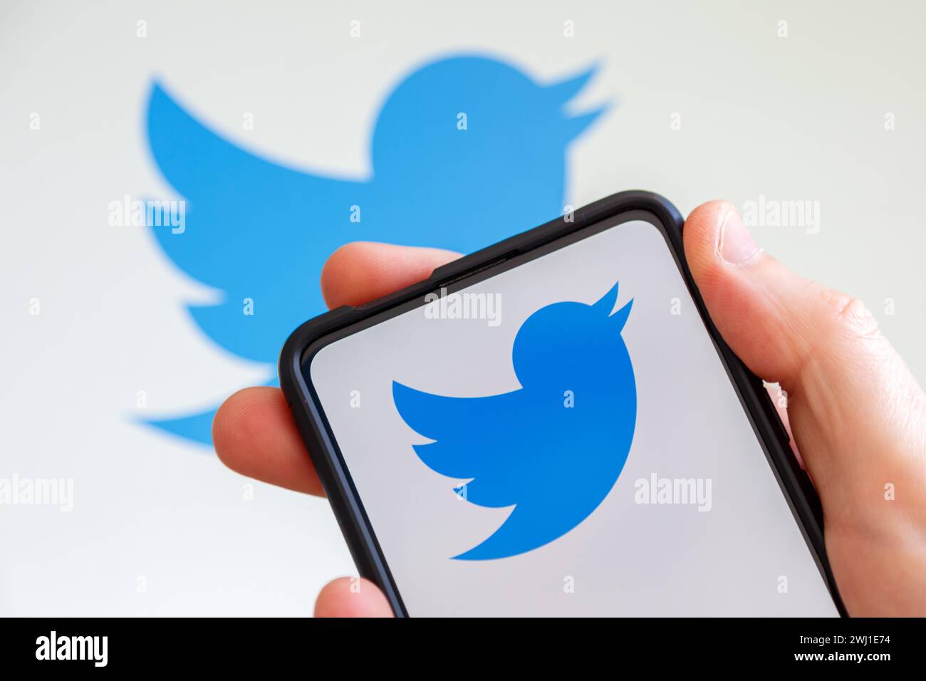 Hand holding cell phone with Twitter logo social media with computer ...