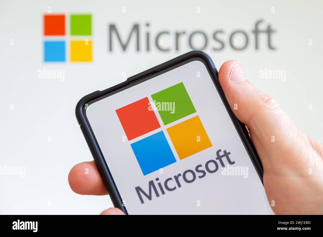 Hand holding cell phone with Microsoft logo of software company ...