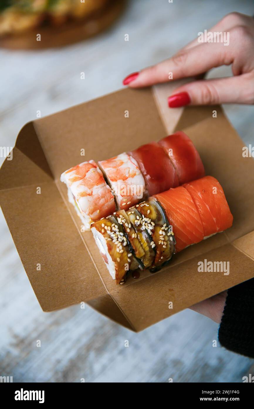 sushi set on packing box in hand Assorted japanese sushi rolls Stock ...
