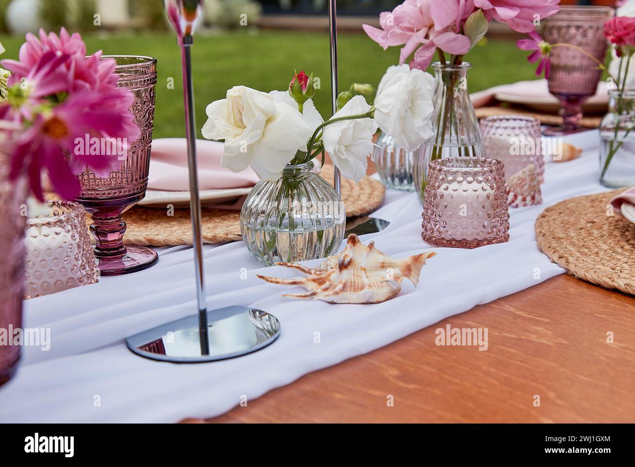 Pink picnic aesthetic table setting, flowers arrangement, shells close ...