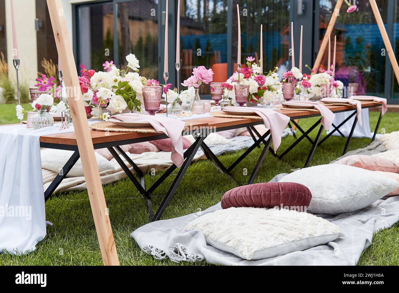 Pink girle aesthetic picnic table setting with pink flowers bouquets, cozy pillows, candles ...