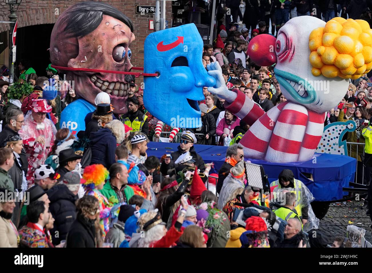 A carnival float depicts a reveller unmasking Adolf Hitler as AfD ...