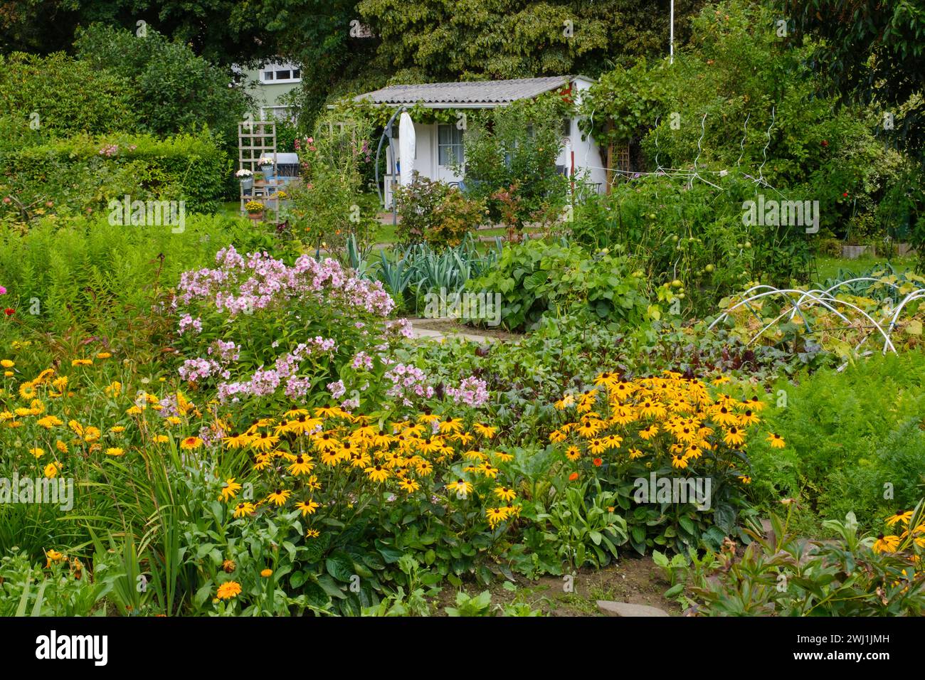 Garden plot with flowers and a bower Stock Photo - Alamy