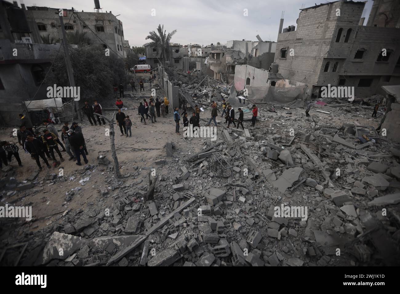 Palestinians inpect the damage in the rubble of a building where two ...