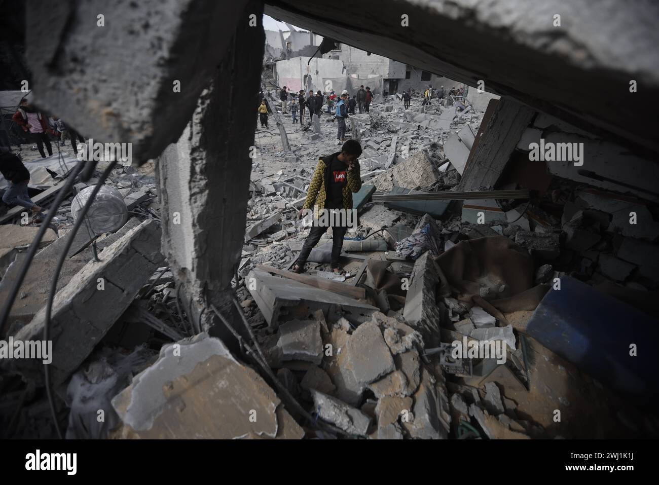 Palestinians inpect the damage in the rubble of a building where two ...