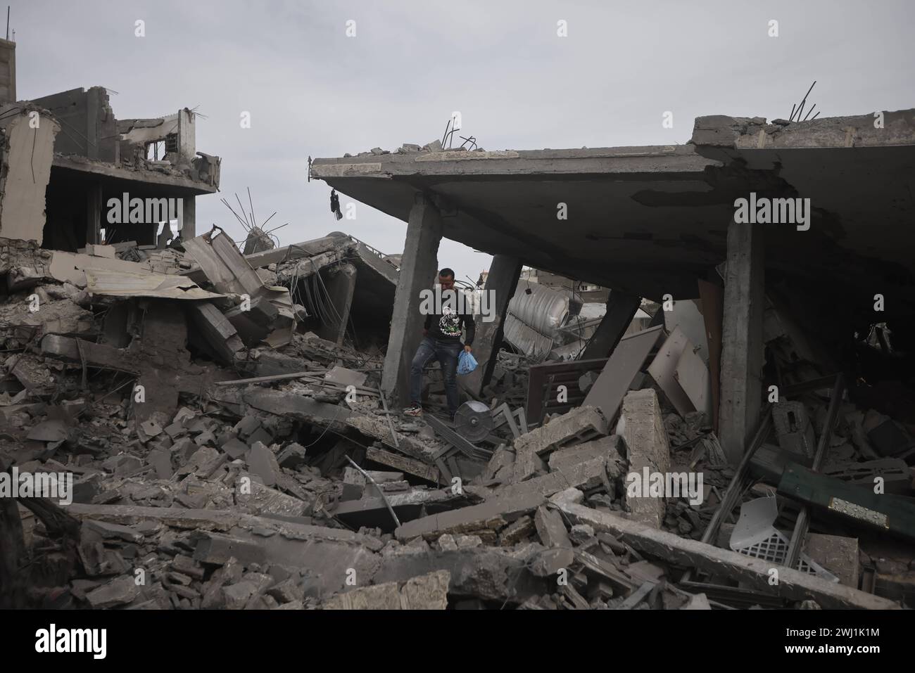 Palestinians inpect the damage in the rubble of a building where two ...