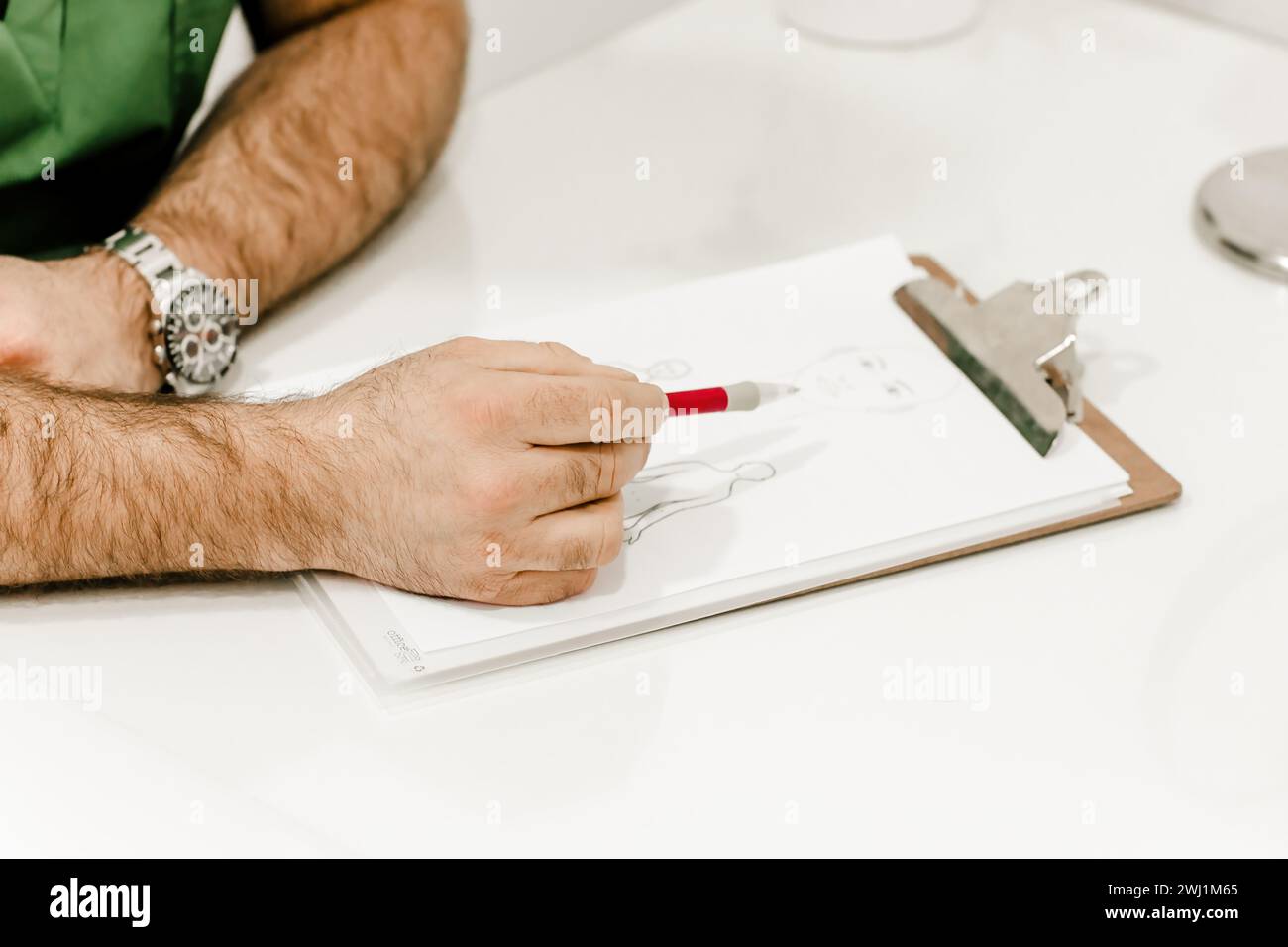 Detailed view of an aesthetic surgeon's hand pointing at a document ...