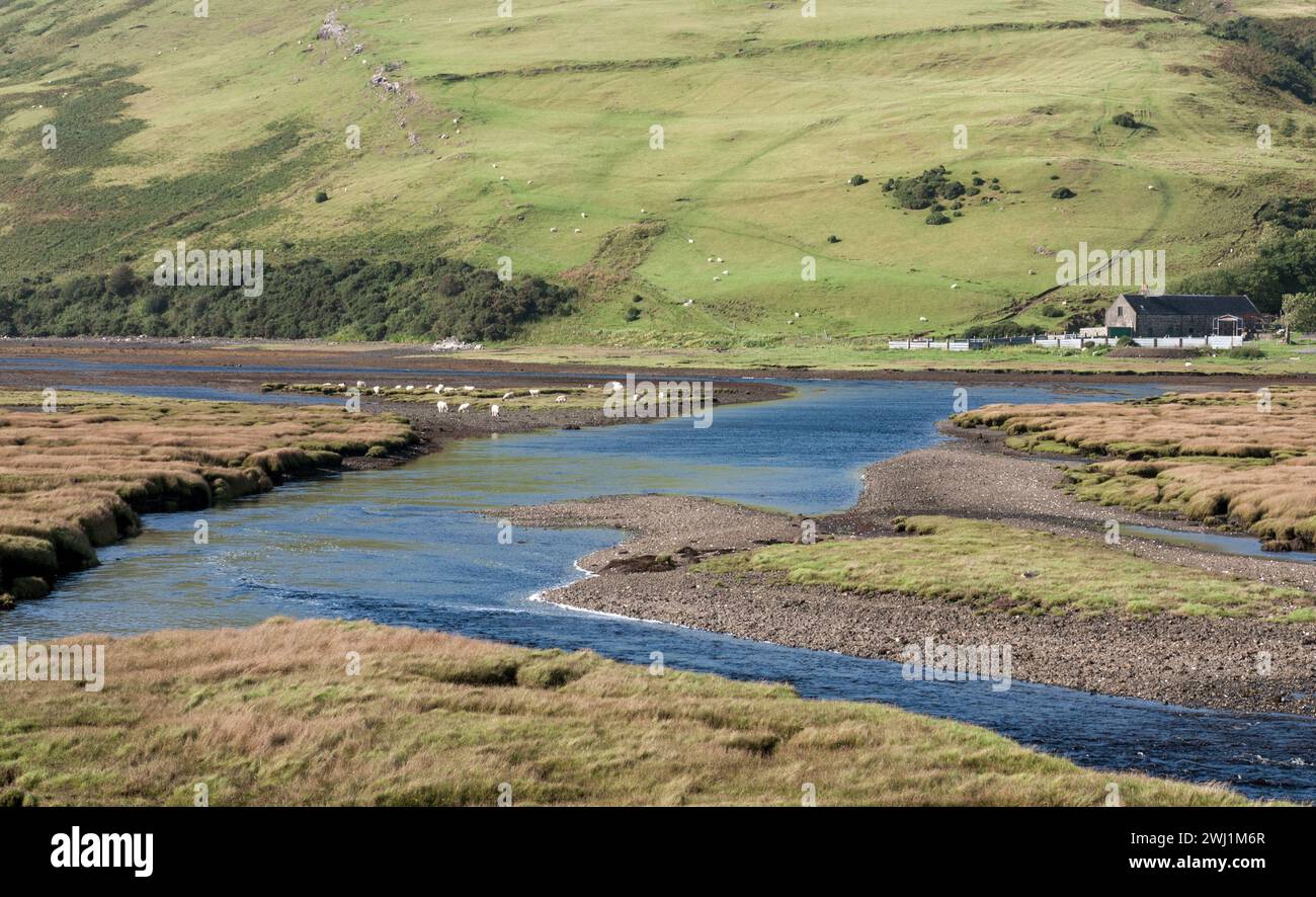 Typical Scottish farmhouse in Glencoe area. River crossing the field ...