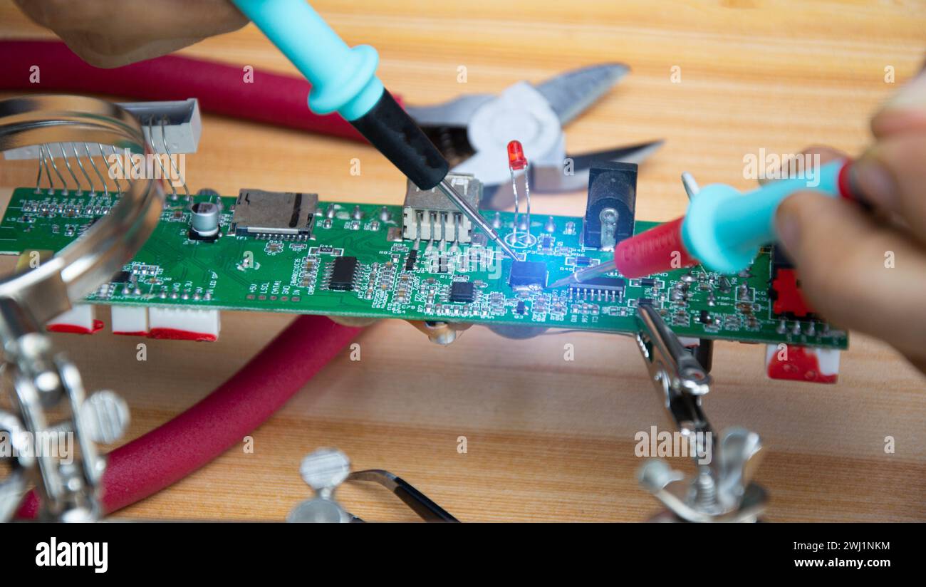 Technicians are repairing motherboards and checking electrical currents ...