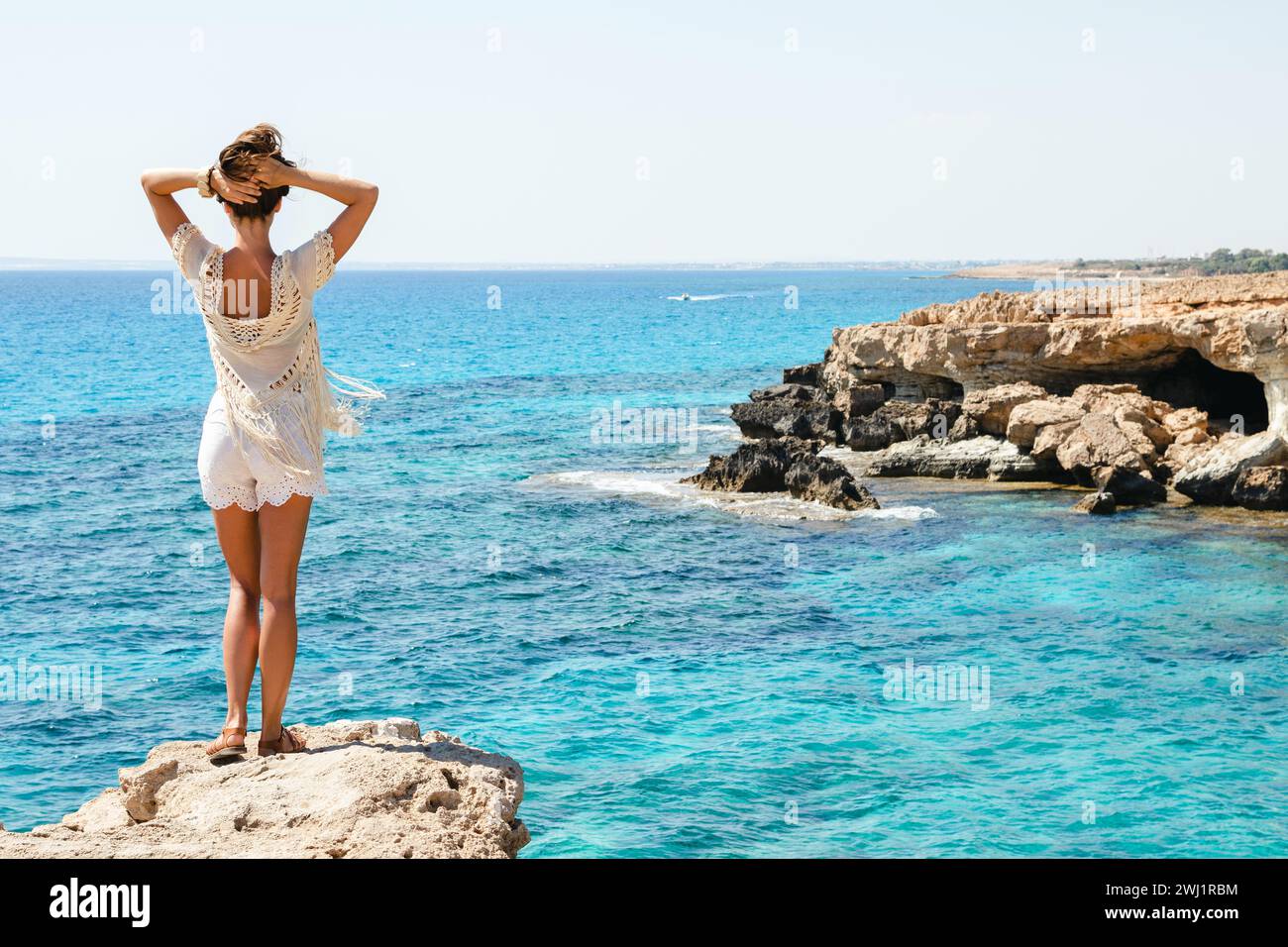 Woman looking on the stunning views from the famous Cape Greco ...