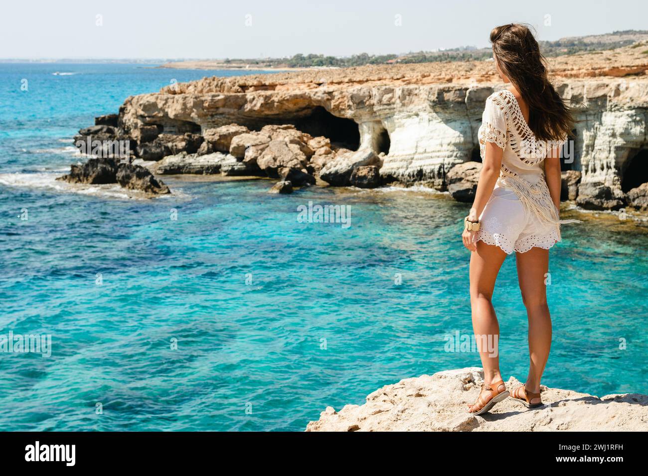 Woman looking on the stunning views from the famous Cape Greco ...