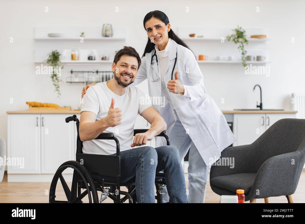 Female doctor hugging smiling male patient with disability posing at ...